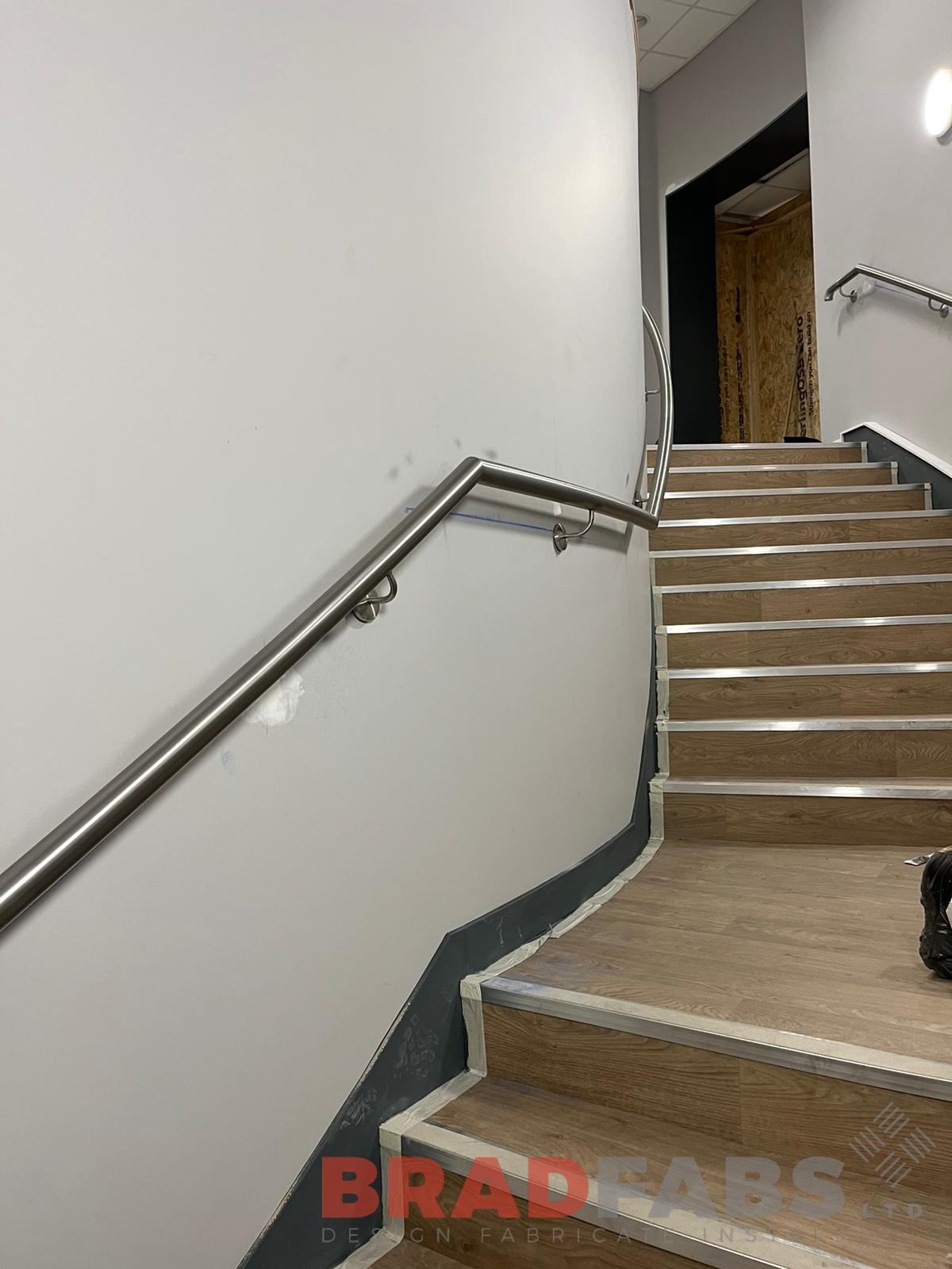 curved indoor staircase with stainless steel handrails by Bradfabs